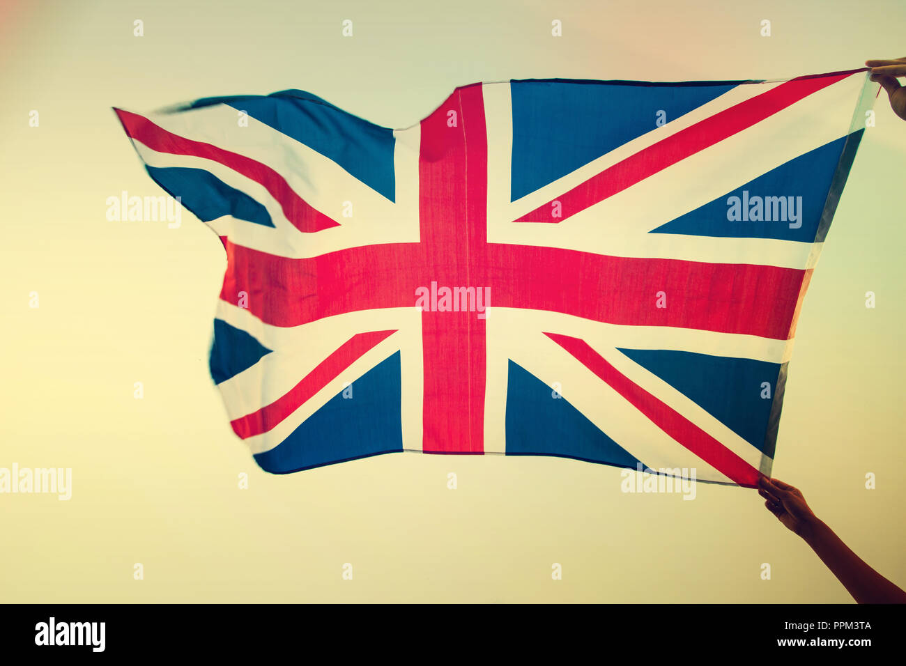 Waving UK flag in the blue sky, Union Jack flag Stock Photo - Alamy