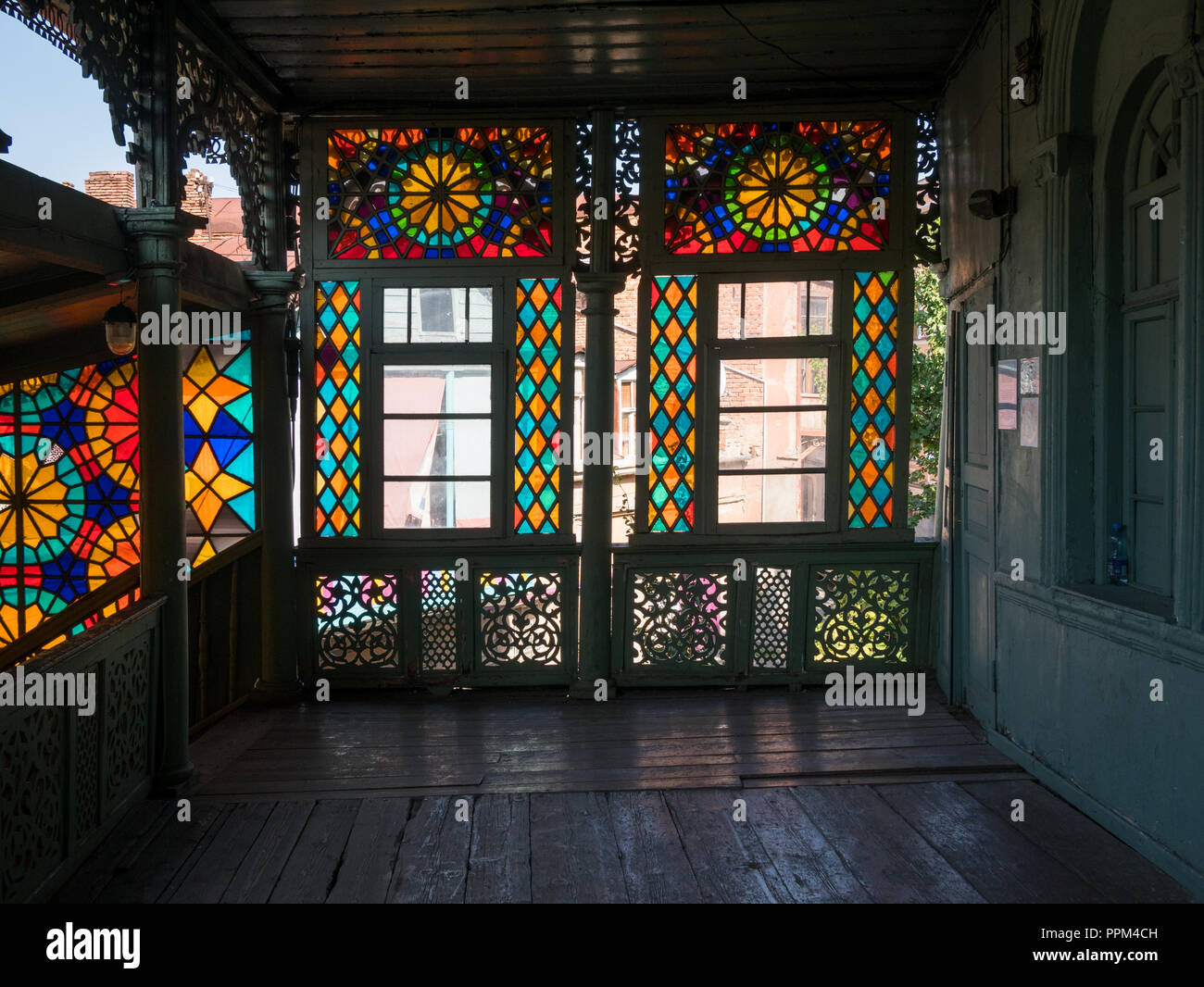 Intricate stained glass window at the top of a balcony in an apartment ...