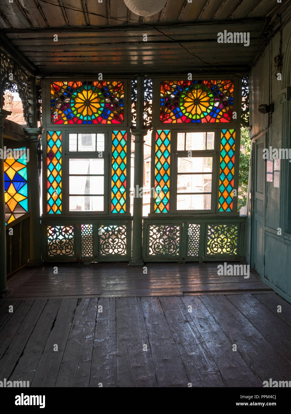 Intricate stained glass window at the top of a balcony in an apartment ...