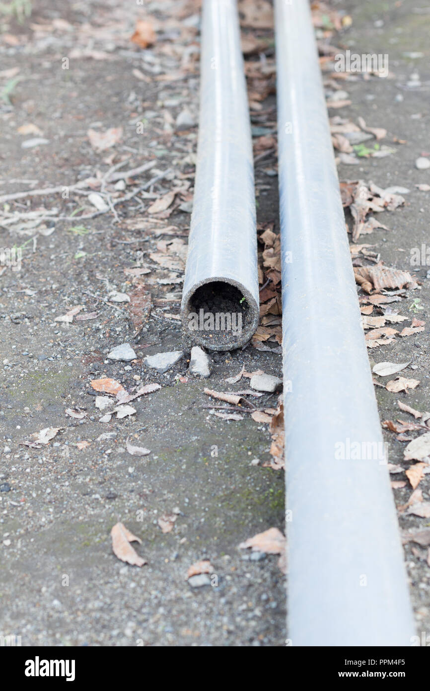 Plastic grey drain pipe filled with some mud Stock Photo - Alamy