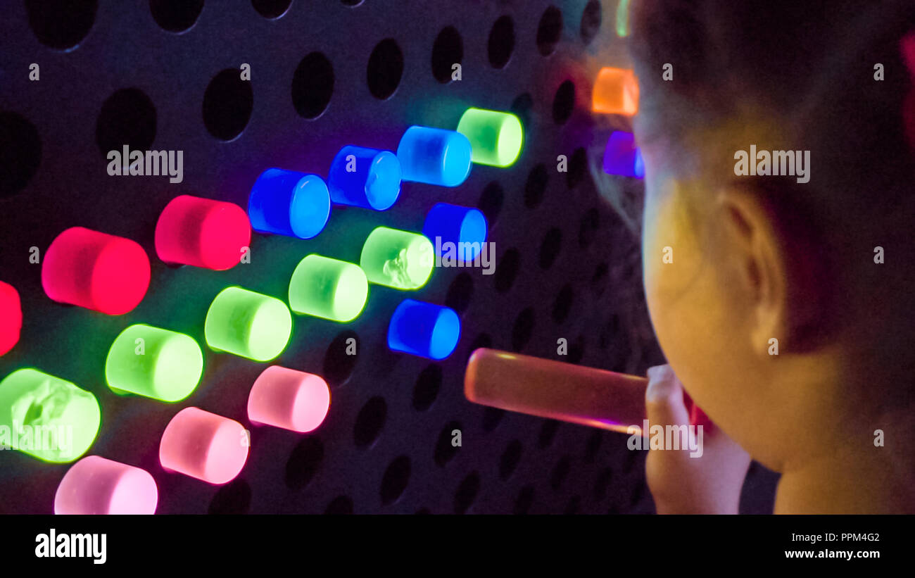 Little girl playing with lights at local science museum Stock Photo - Alamy