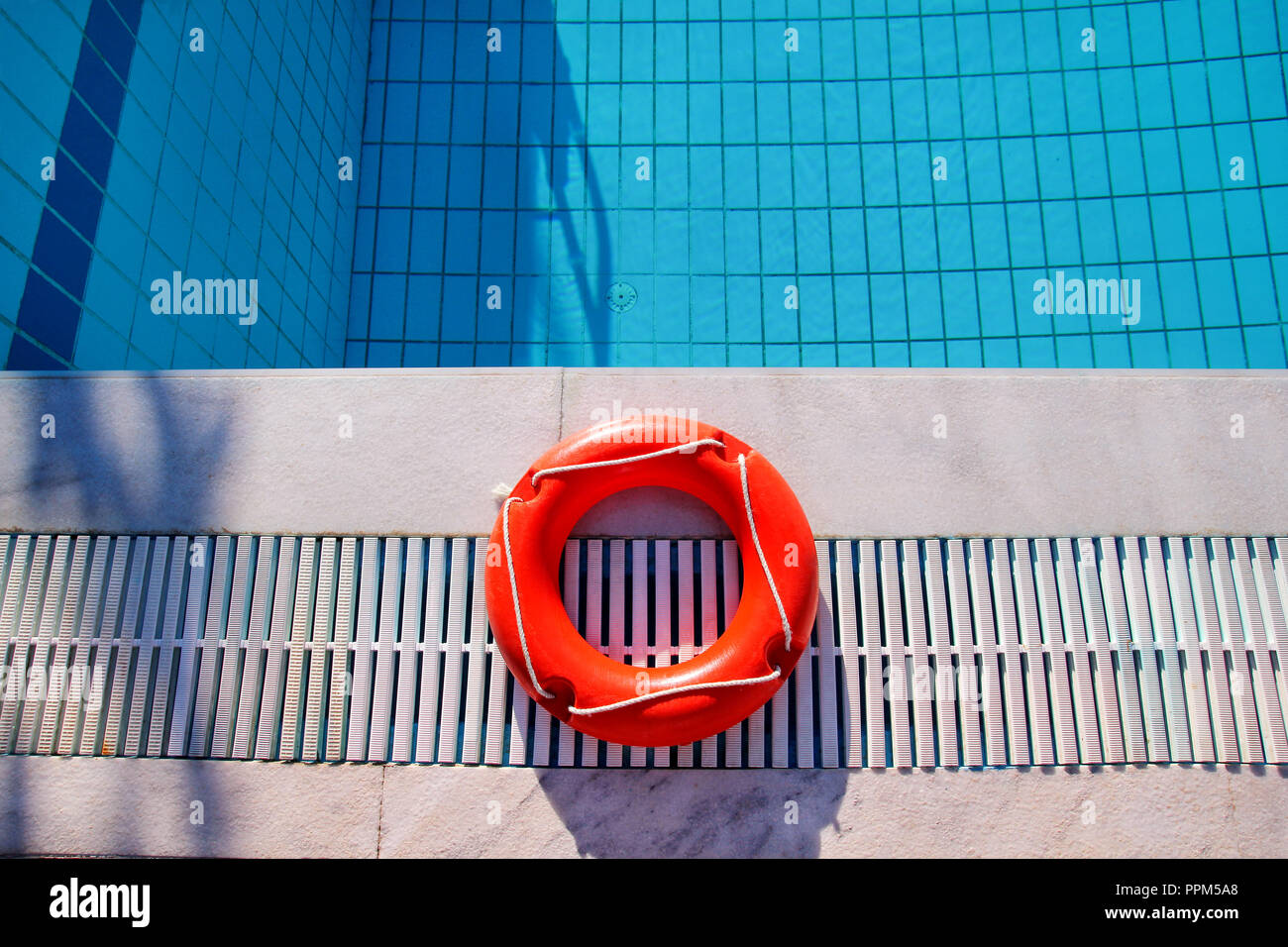 Red lifebuoy pool ring at swimming pool. Red pool ring in cool blue ...