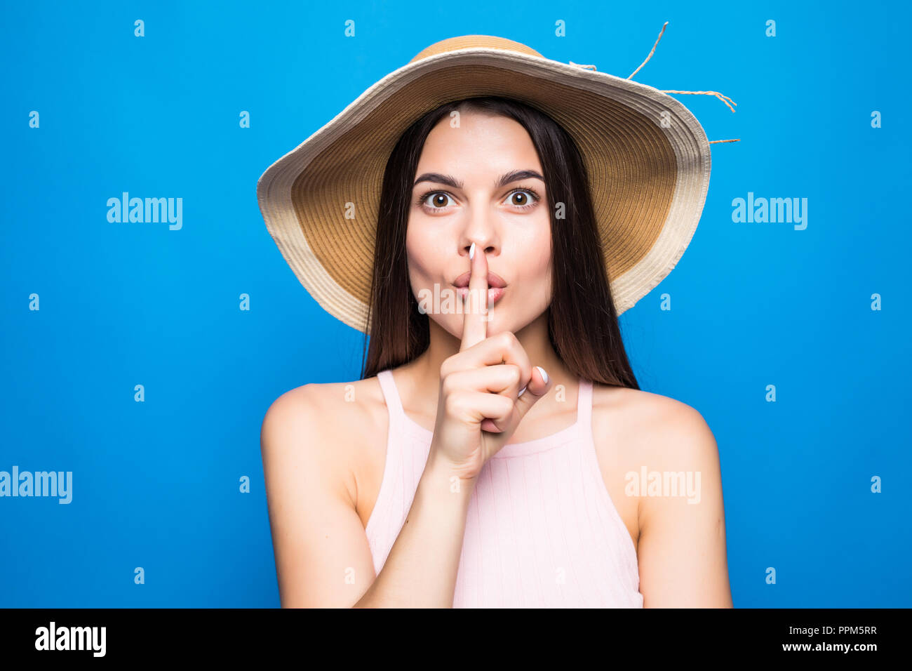 Attractive young woman with index finger to lips hi-res stock ...