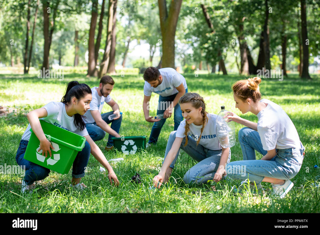 young volunteers cleaning green park together Stock Photo - Alamy