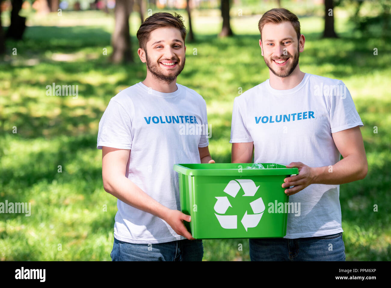 young male volunteers with green recycling box Stock Photo - Alamy