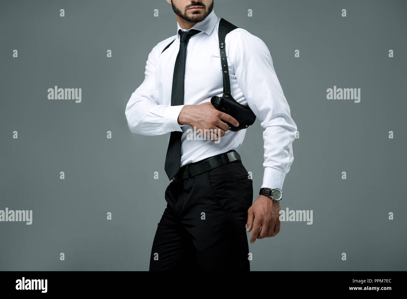 cropped image of security guard taking gun isolated on grey Stock Photo ...