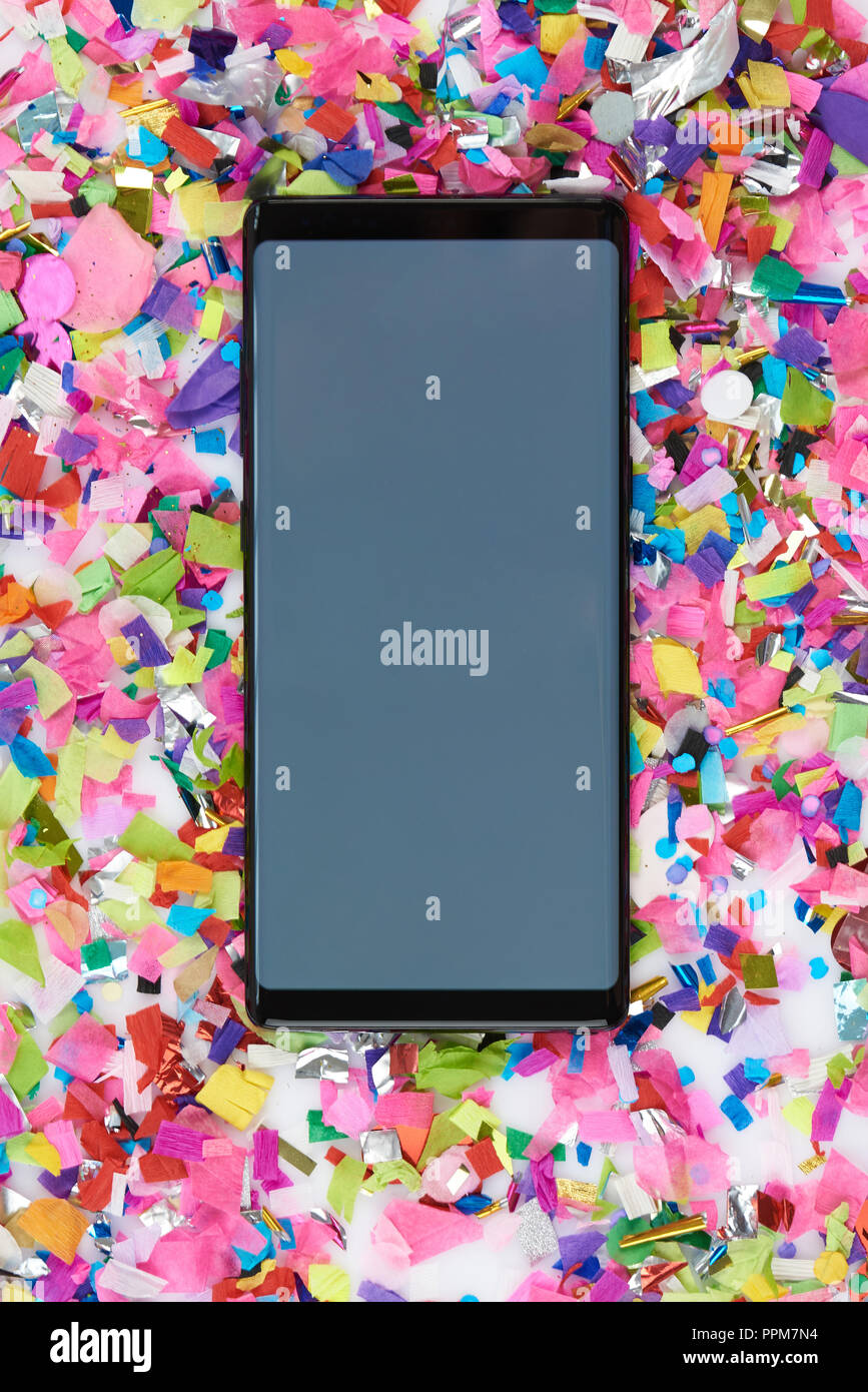 Smartphone empty screen on top of colorful confetti Stock Photo - Alamy