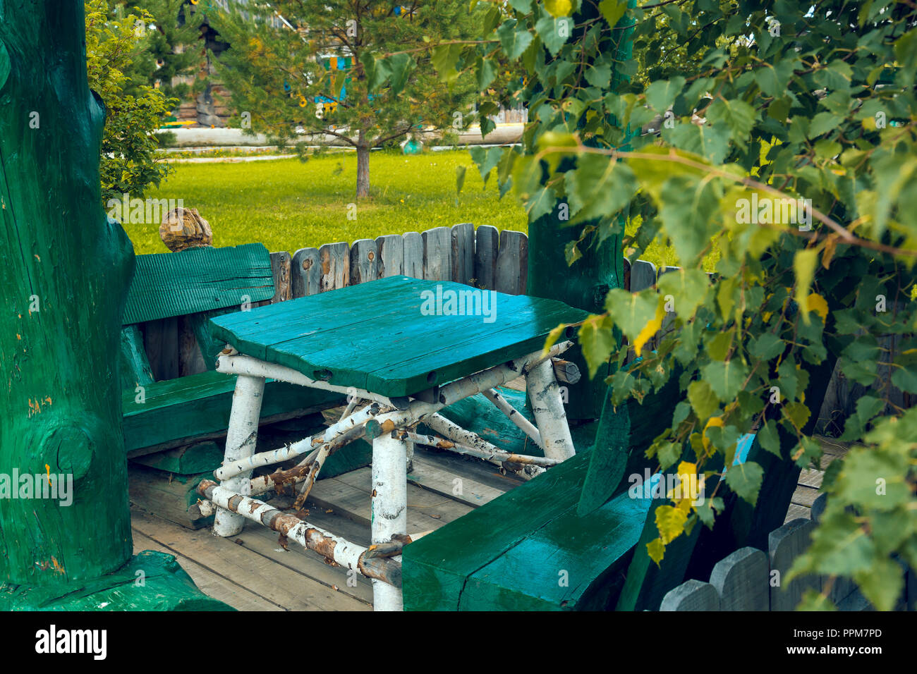 A table of birch tree trunks with black stripes and green boards with ...
