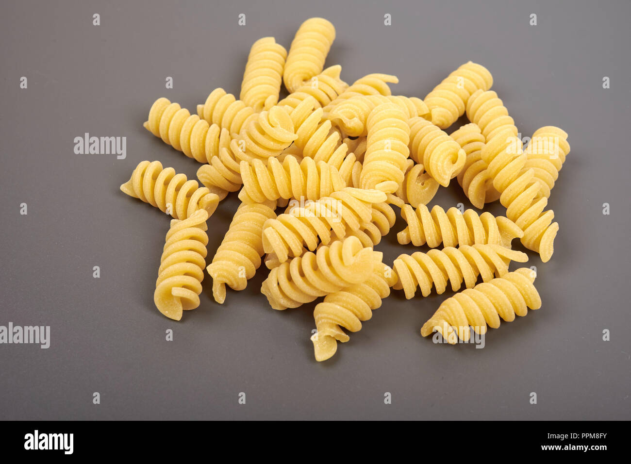 uncooked fusilli pasta noodles isolated on grey background Stock Photo ...