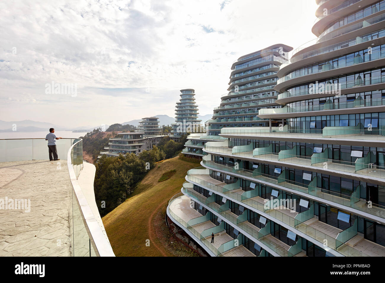 Exterior view with man looking out from a balcony. Huangshan Village ...