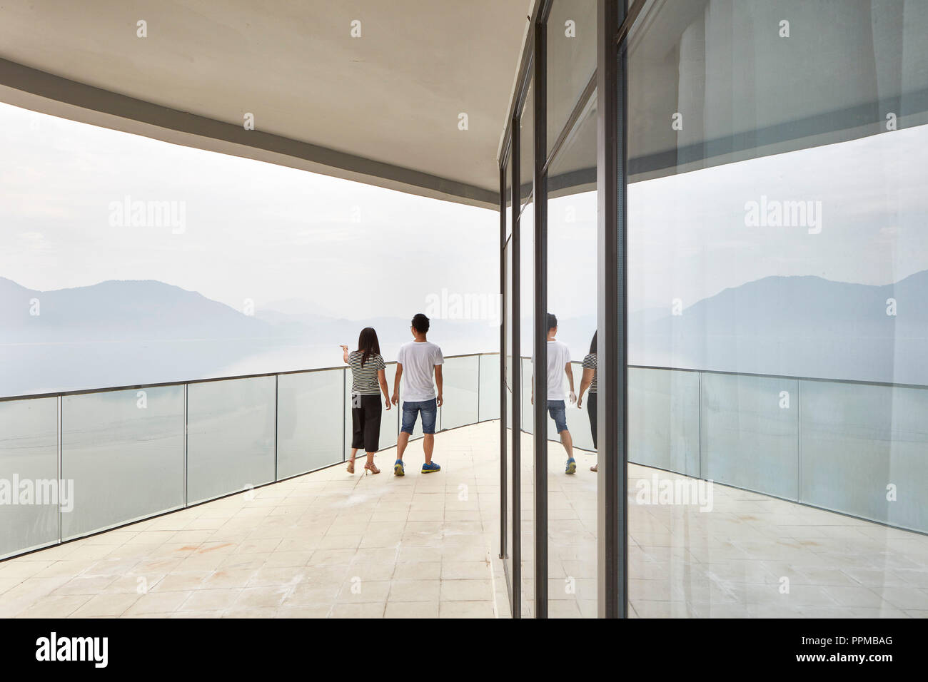 Man and woman looking from balcony across Taiping Lake. Huangshan ...