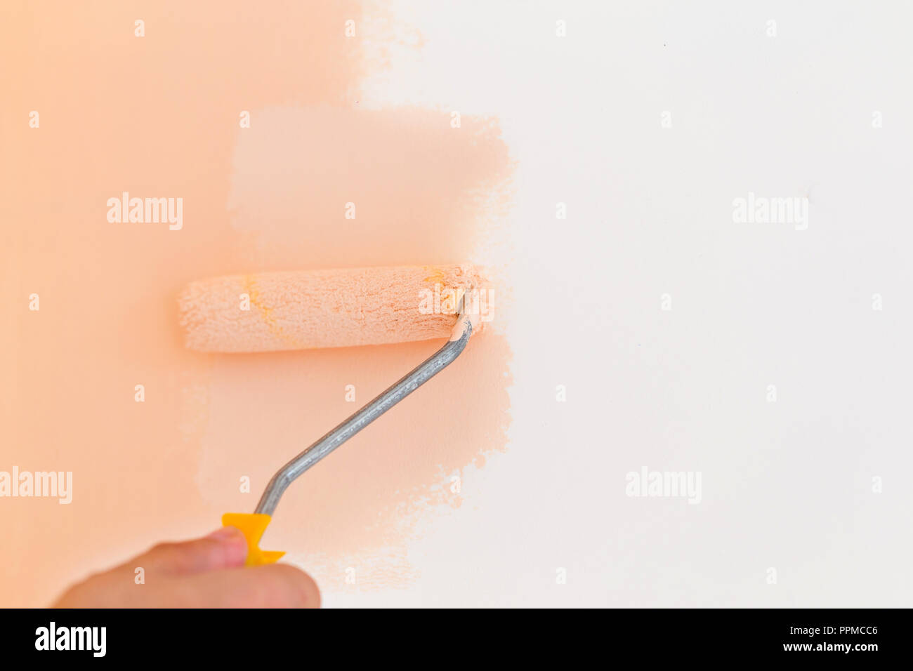 Home wall improvement beige painting by roller worker Stock Photo - Alamy