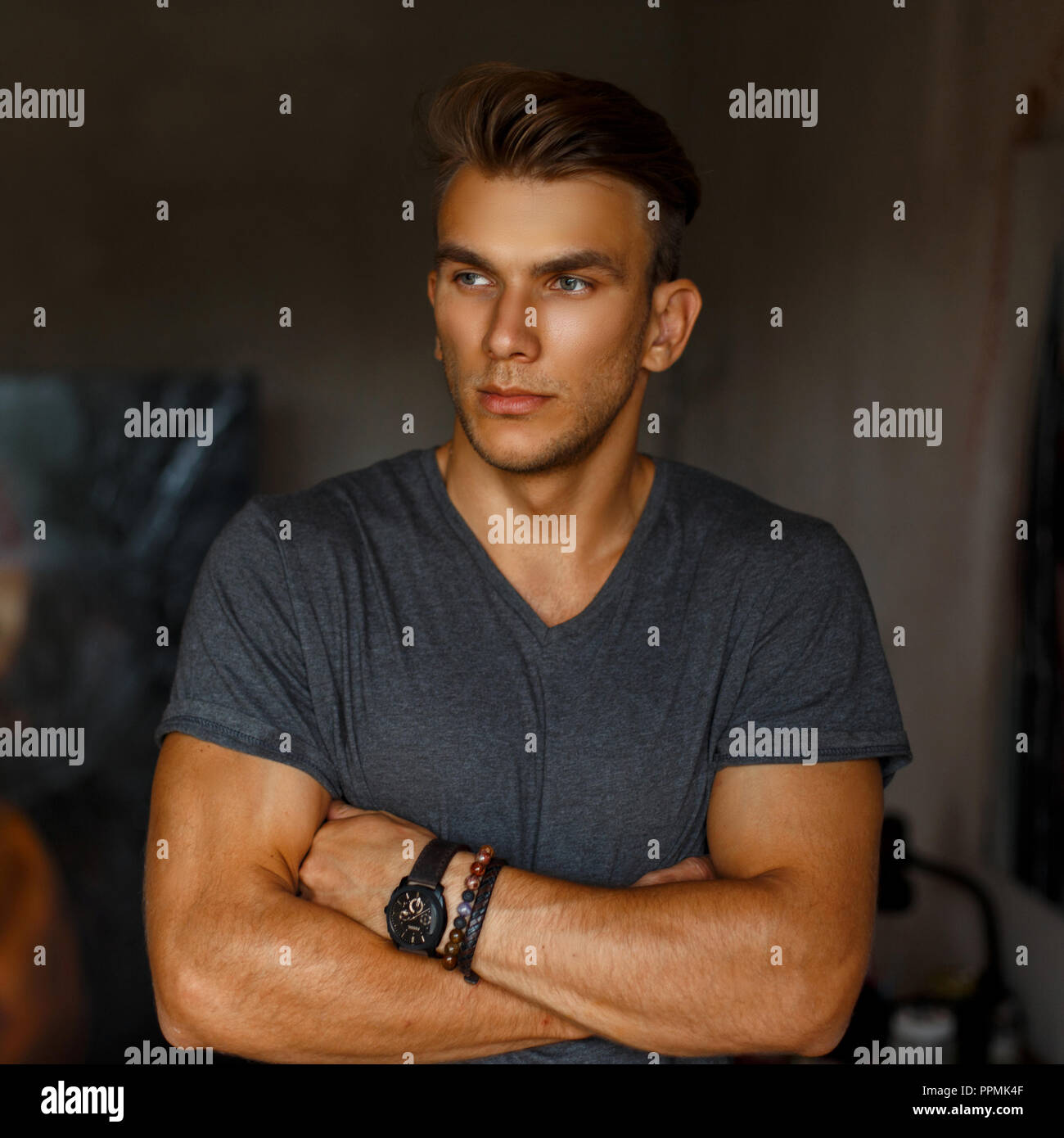 Stylish handsome young man with a hairstyle in a gray T-shirt in the ...