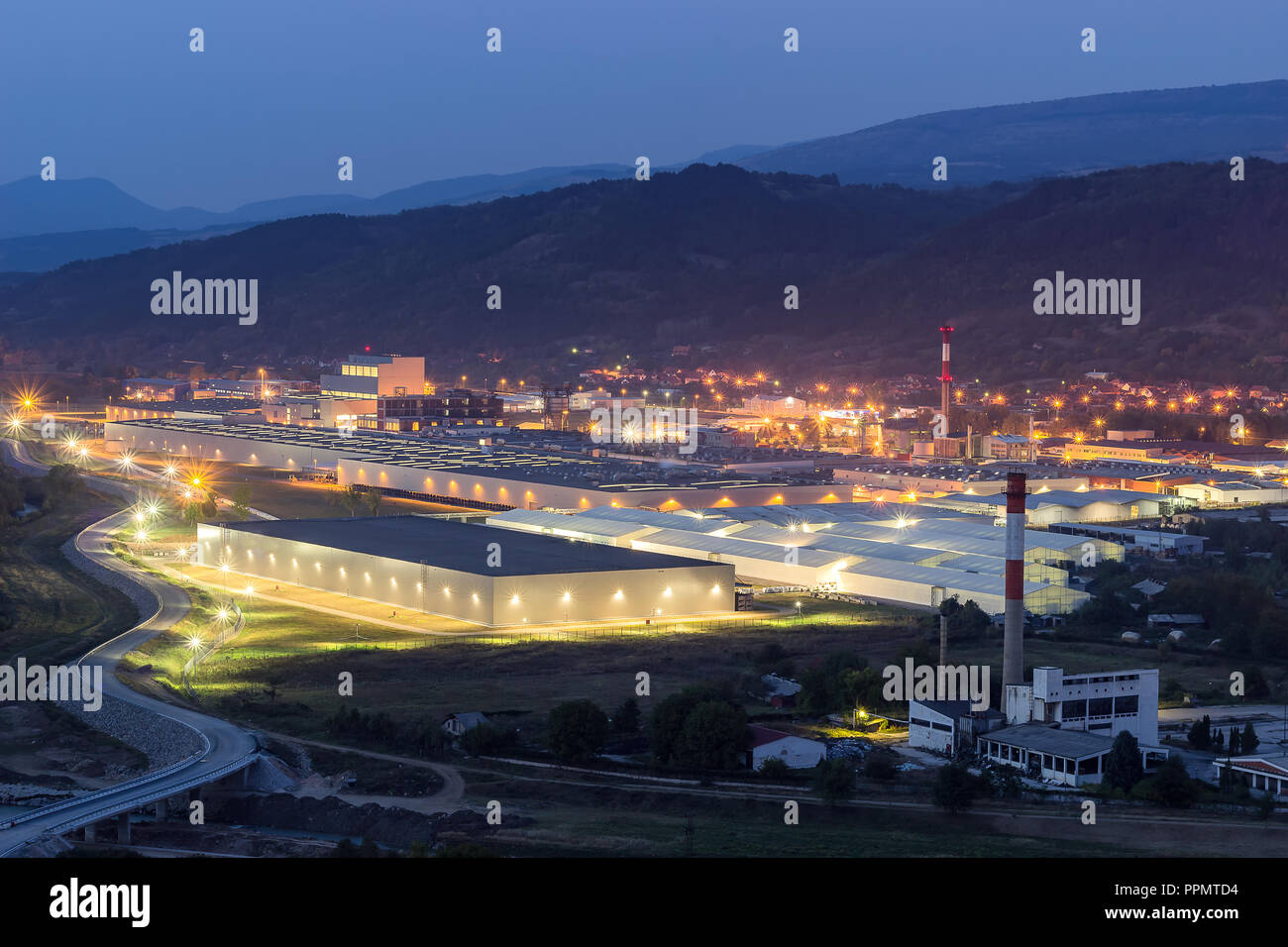 Illuminated modern factory and old, ruined factory night view from ...