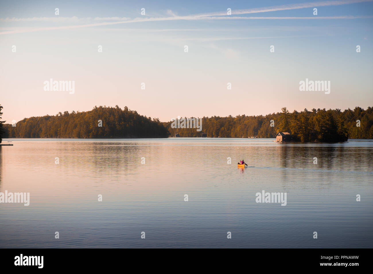 Canoe on tranquil Lake Joseph, Muskoka, at sunrise Stock Photo - Alamy