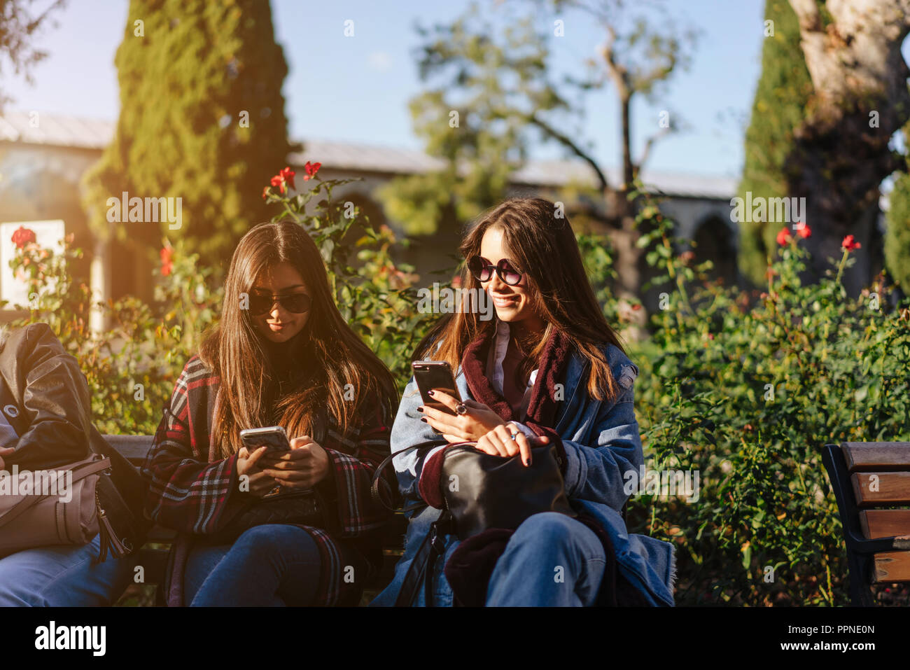 Two girls are resting on the bench Stock Photo - Alamy