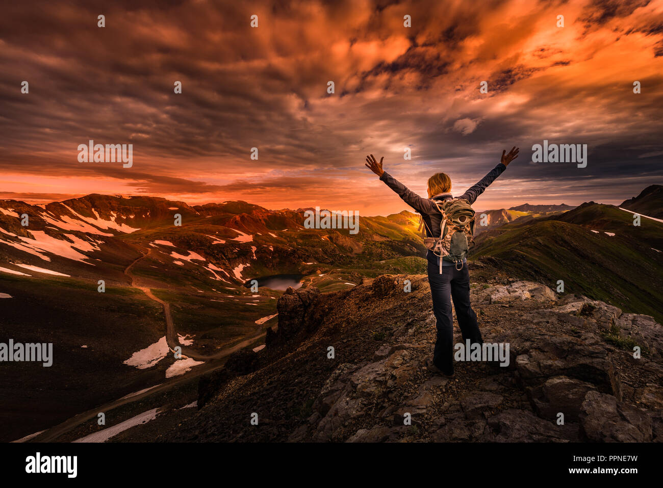 Young Woman Backpacker in Victory Pose with raised up arms on top of ...