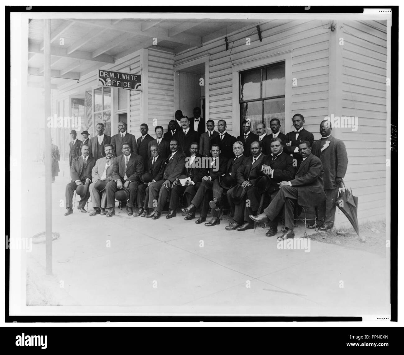 Booker T. Washington seated with group of men outside the office of Dr ...