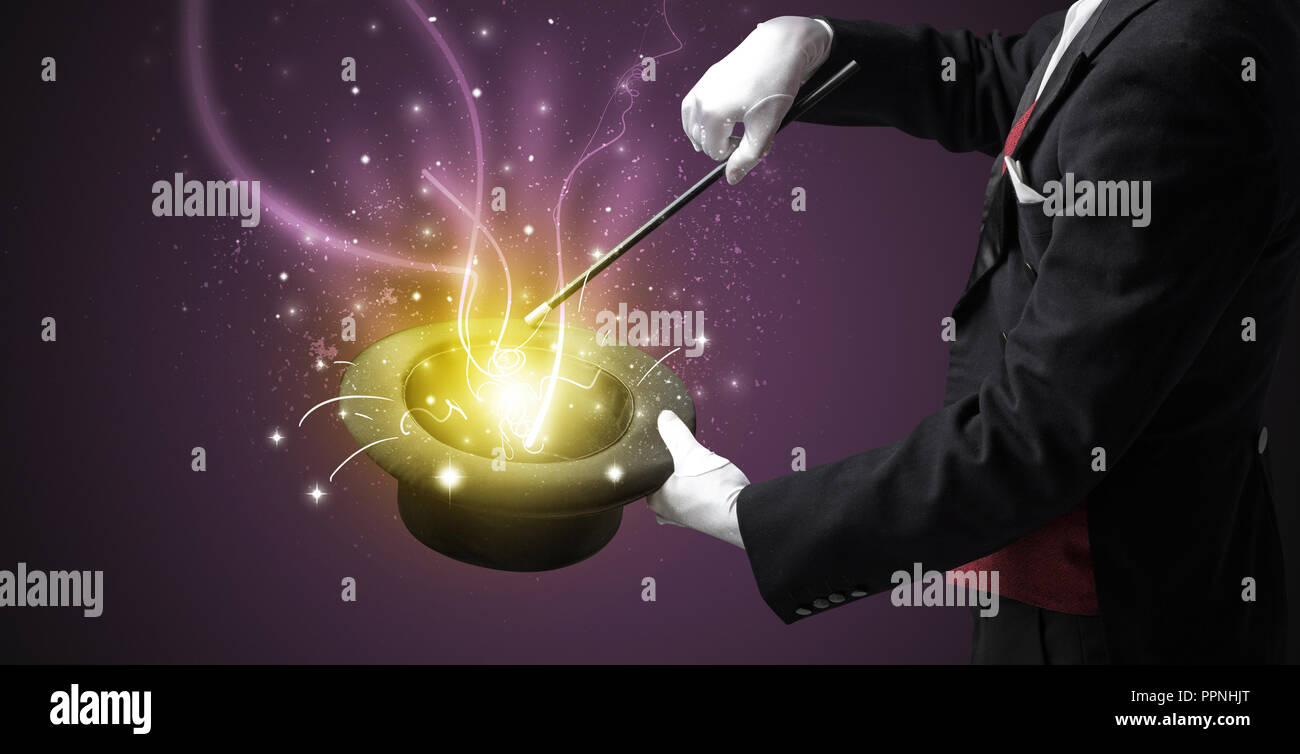 Magician hand conjure with wand light from a black cylinder Stock Photo ...