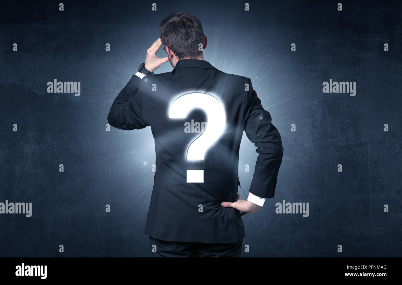 Businessman standing and thinking about questions Stock Photo - Alamy