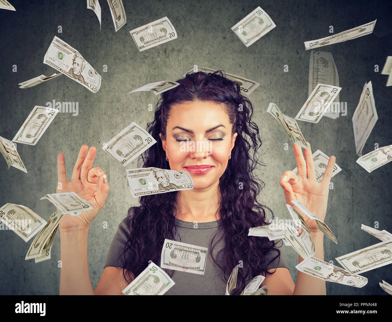 Happy business woman meditating under money rain Stock Photo - Alamy