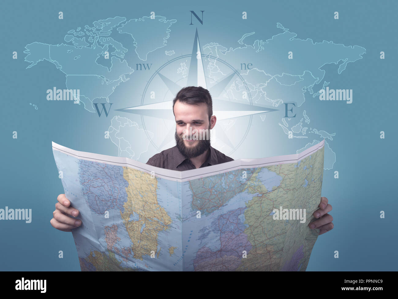 Handsome young man holding a map with a world map and a compass behind ...