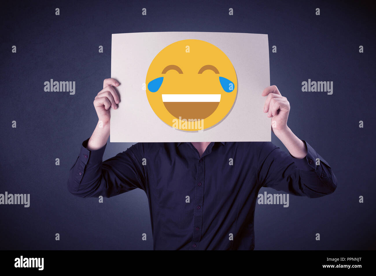 Young businessman hiding behind a laughing emoticon on cardboard Stock ...