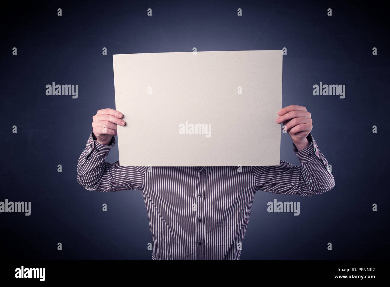 Young businessman hiding behind a blank piece of paper Stock Photo - Alamy