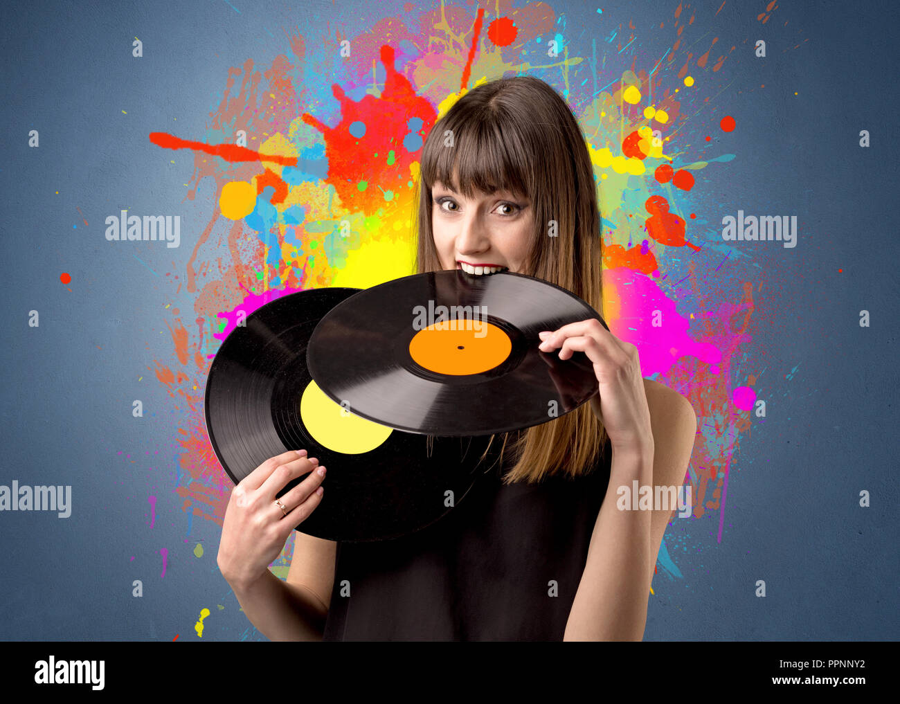 Young lady holding vinyl record on a grey background with colorful ...