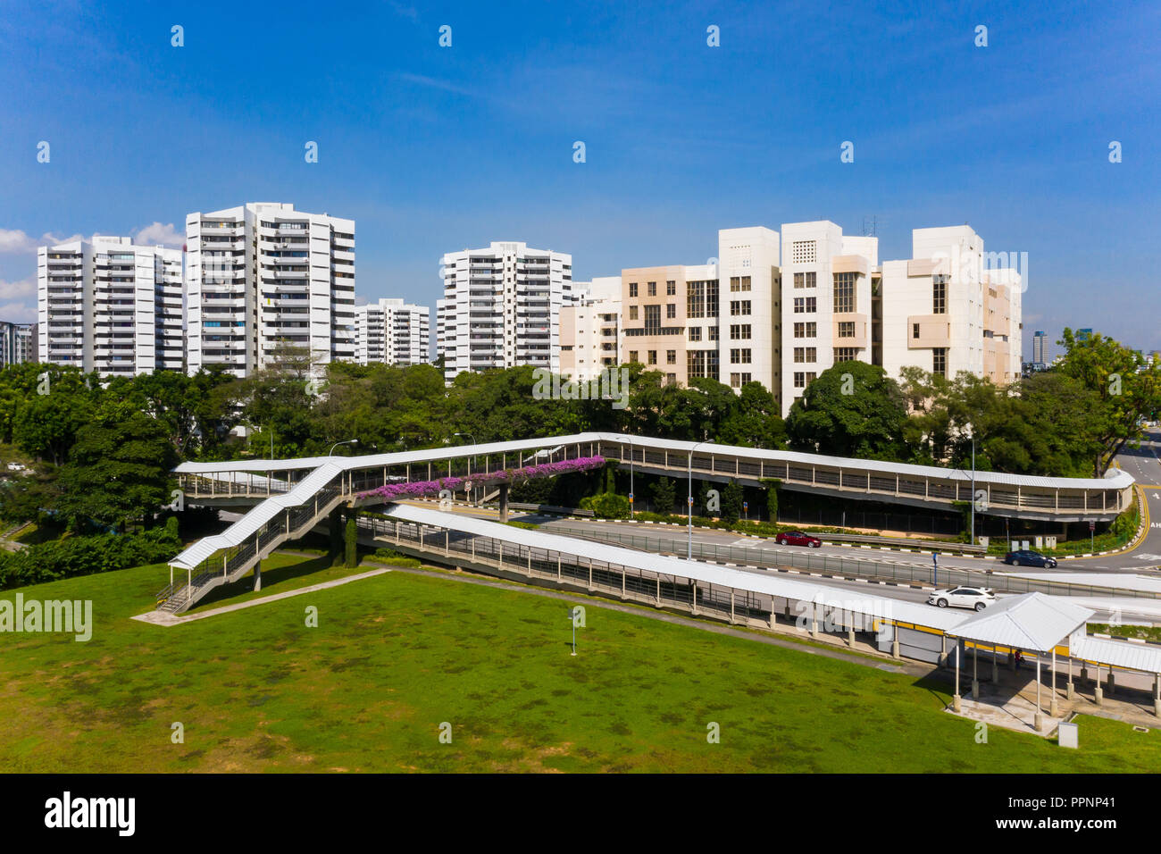 A lengthy overhead bridge connects between housing and bus stop along ...