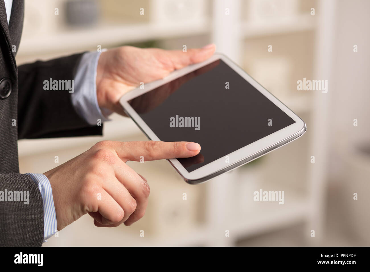 Business woman below chest using tablet in a homey environment Stock ...
