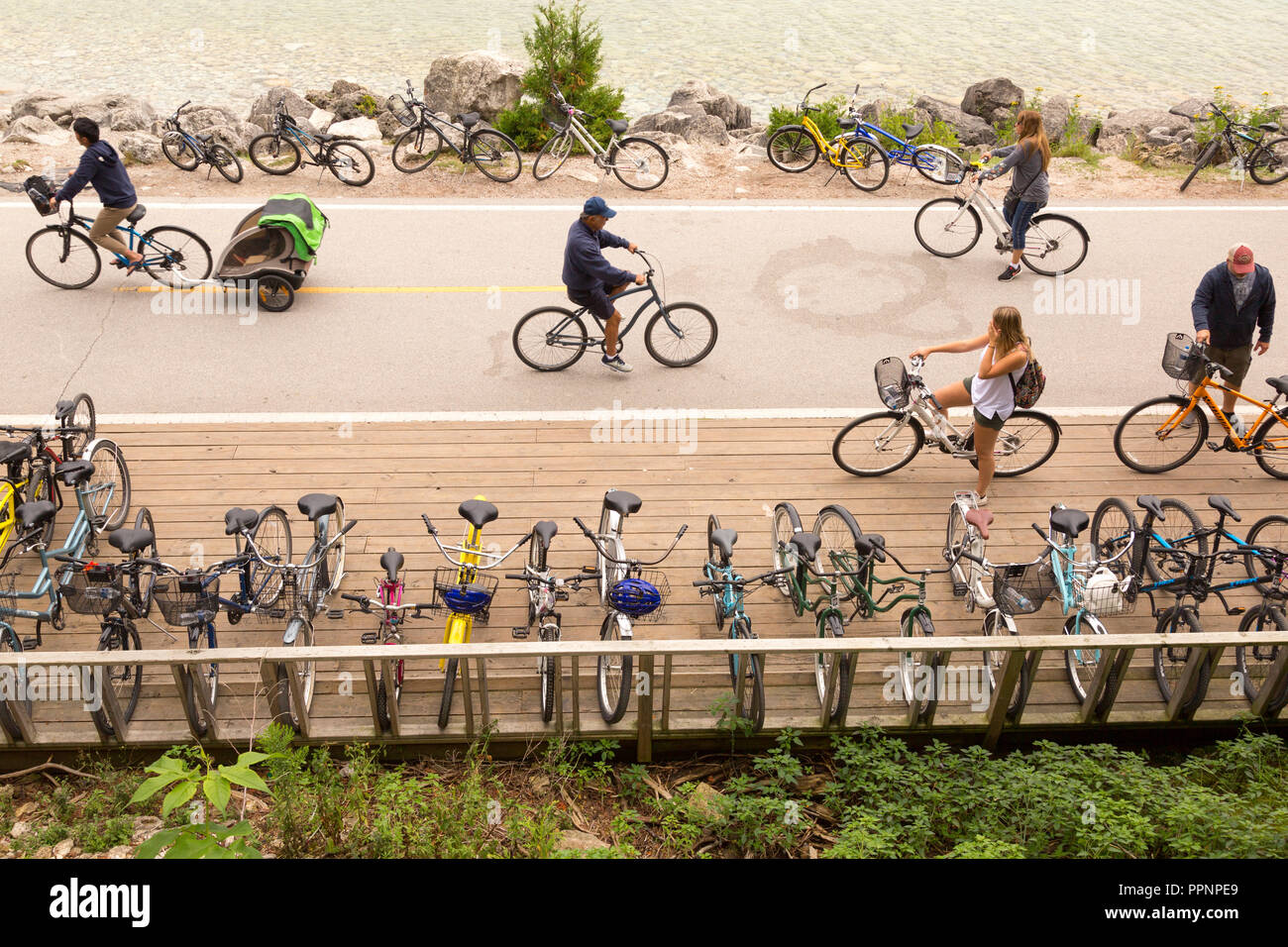 Men, woman and children riding bike on bike path along Lake Huron on ...