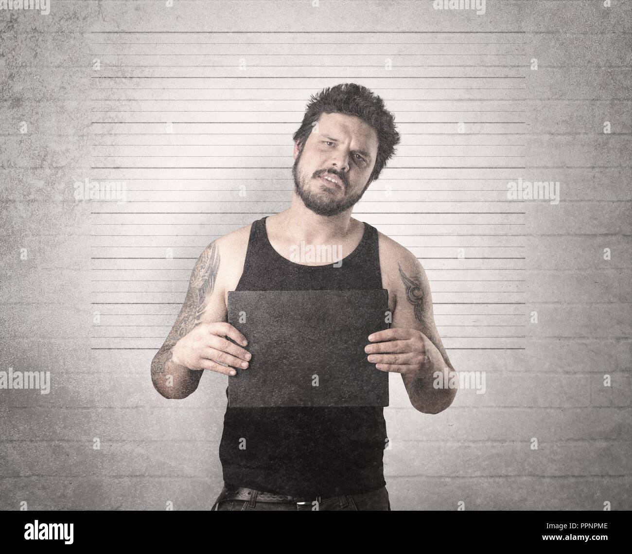 Gangster in front of a wall with table on his hand Stock Photo - Alamy