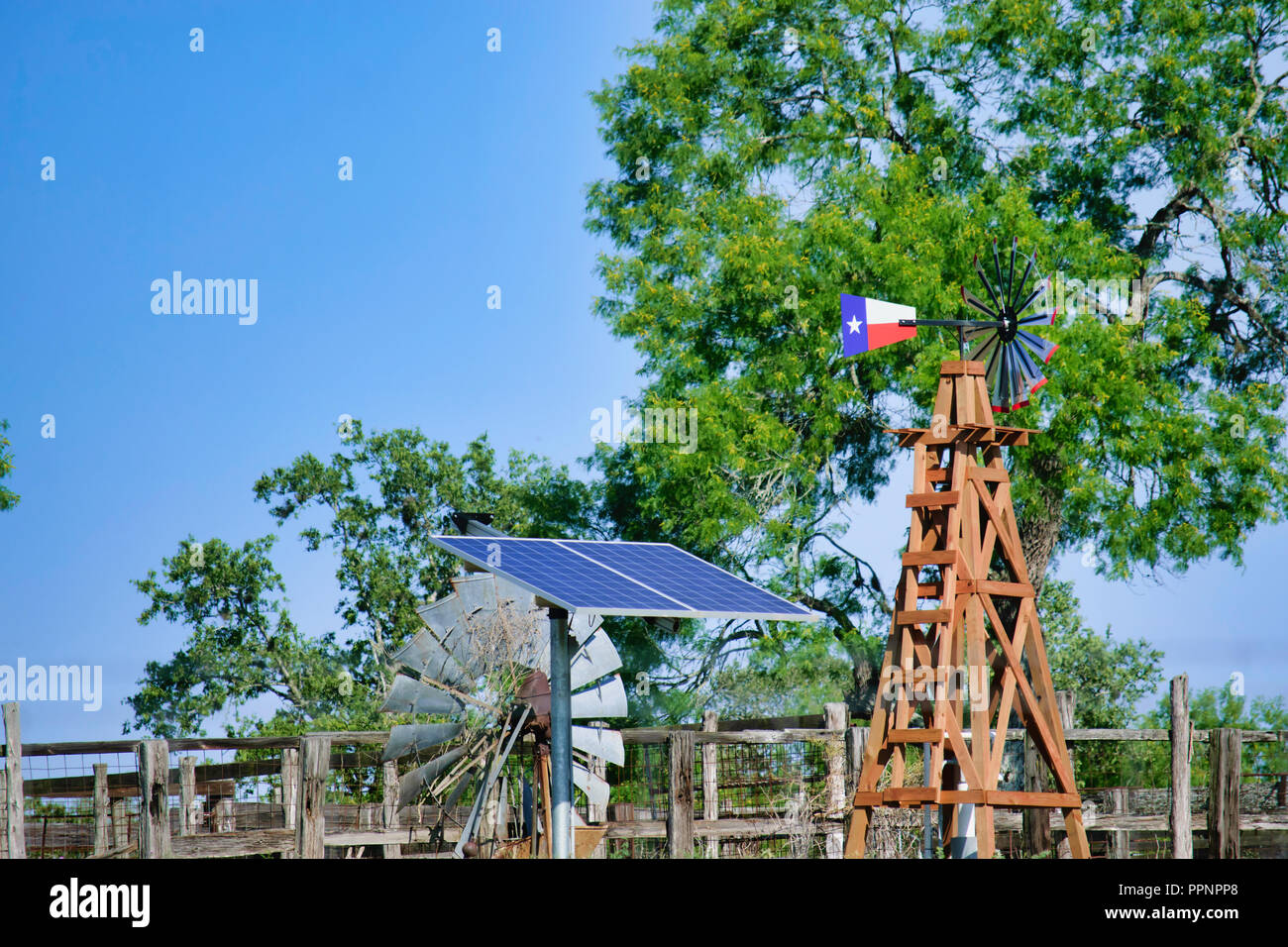 Solar Water well with Texas Windmill in front of summer green trees ...