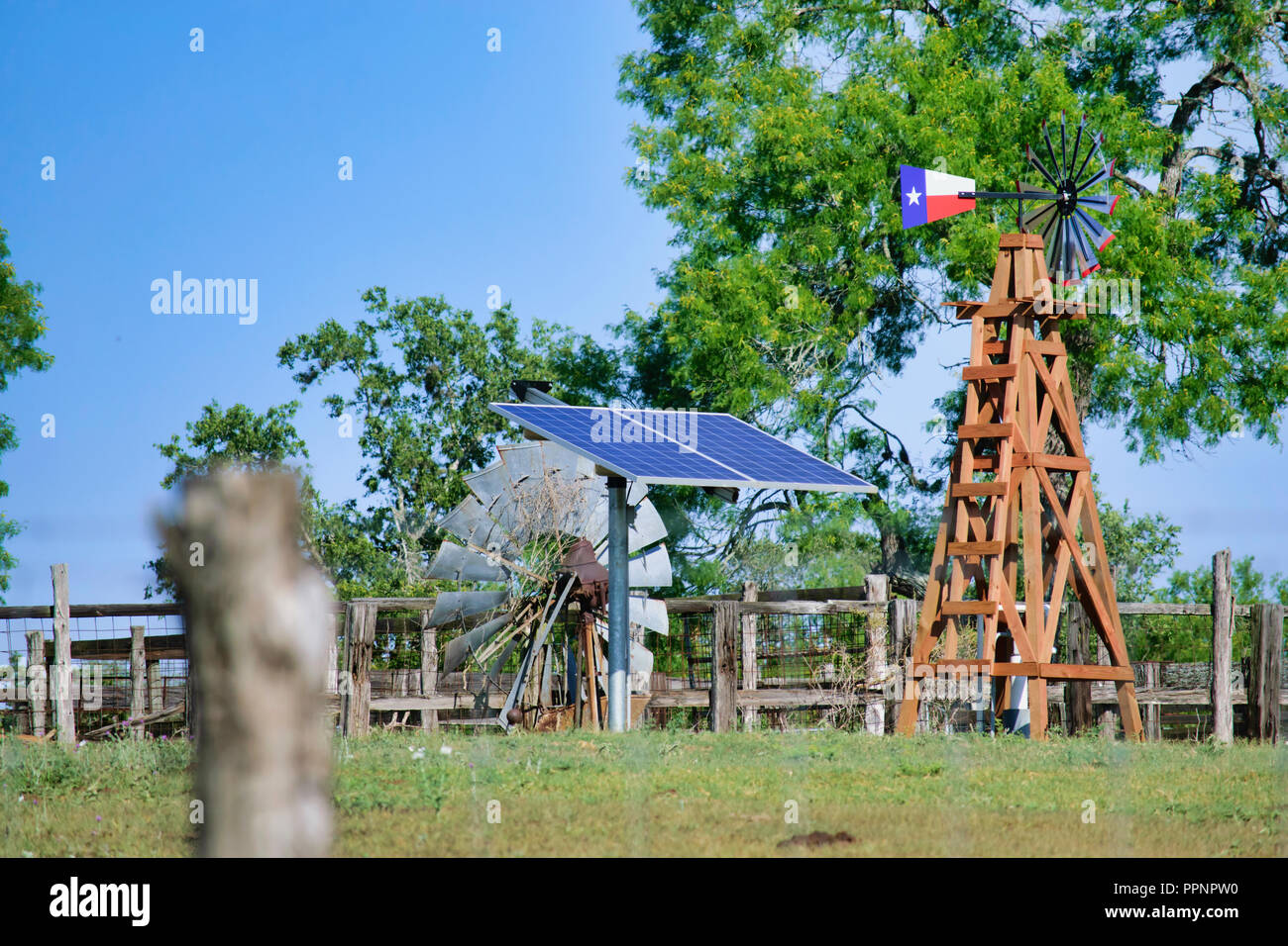 Solar Water well with Texas Windmill in front of summer green trees ...