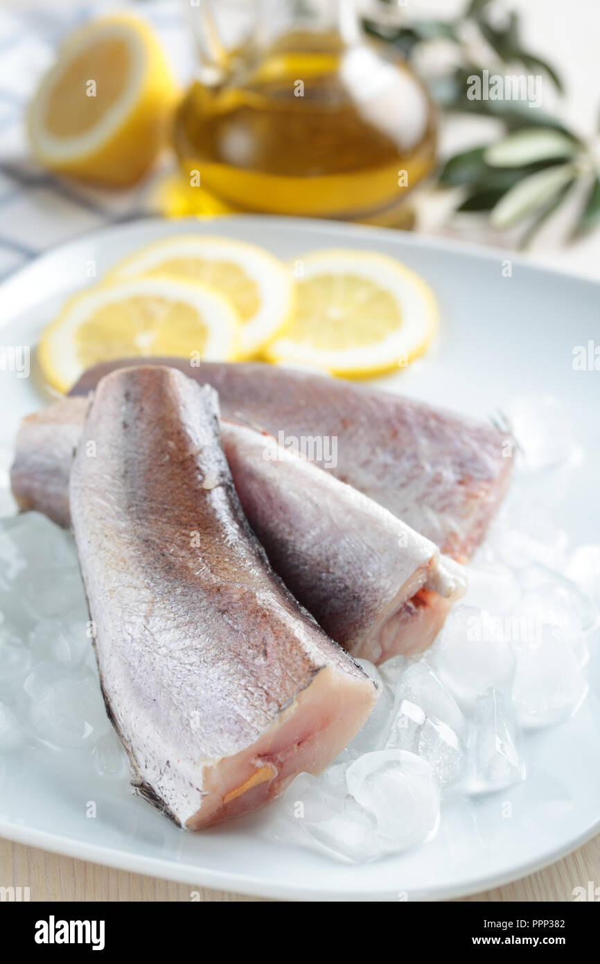 Raw hake on ice and slices of lemon Stock Photo - Alamy