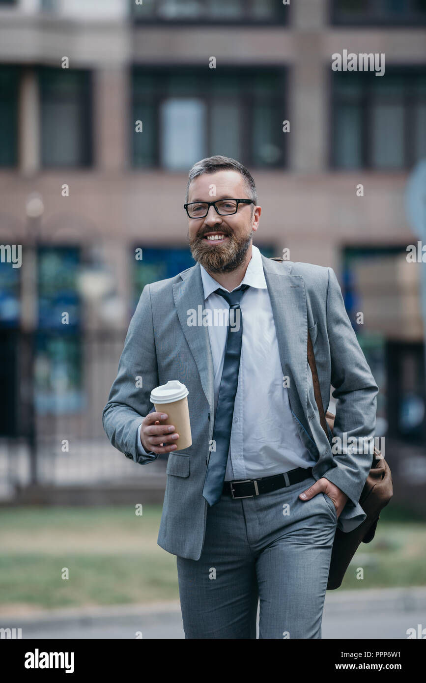 Smiling businessman paper cup walking hi-res stock photography and ...