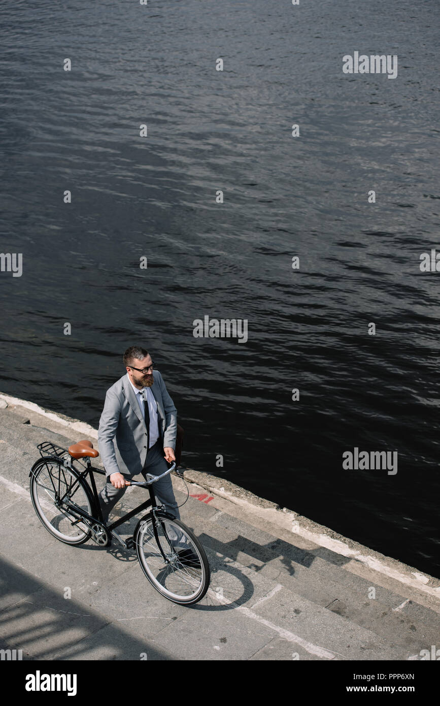 overhead view of businessman with bike walking on quay Stock Photo - Alamy