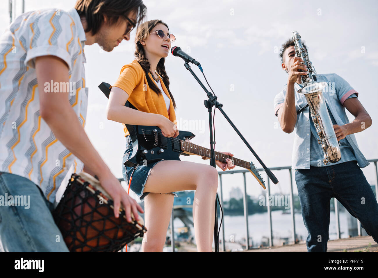 Multiracial young people with guitar, djembe and saxophone playing ...