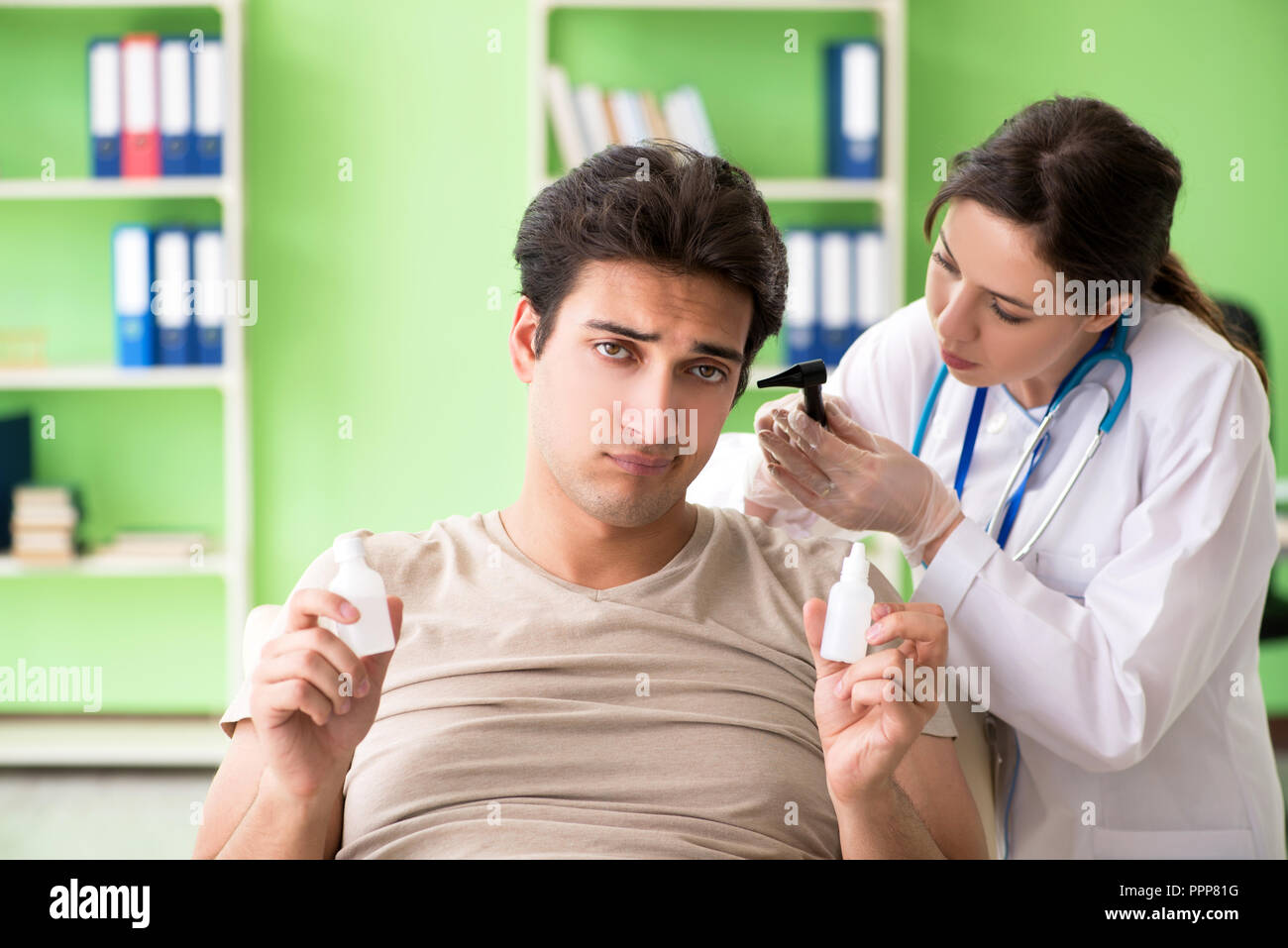 Female doctor checking patient's ear during medical examination Stock ...