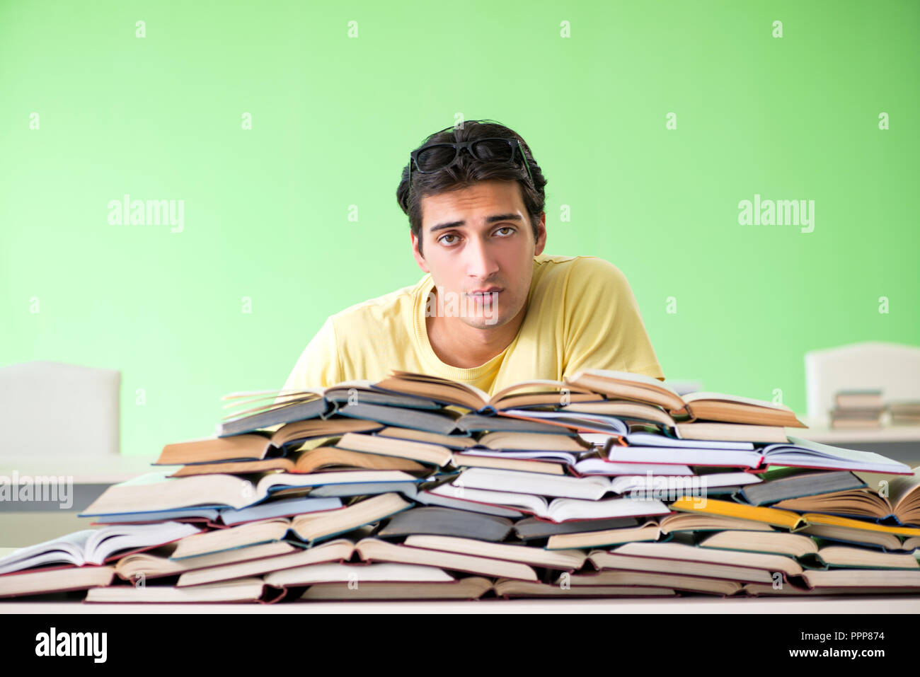 Student with too many books to read before exam Stock Photo - Alamy