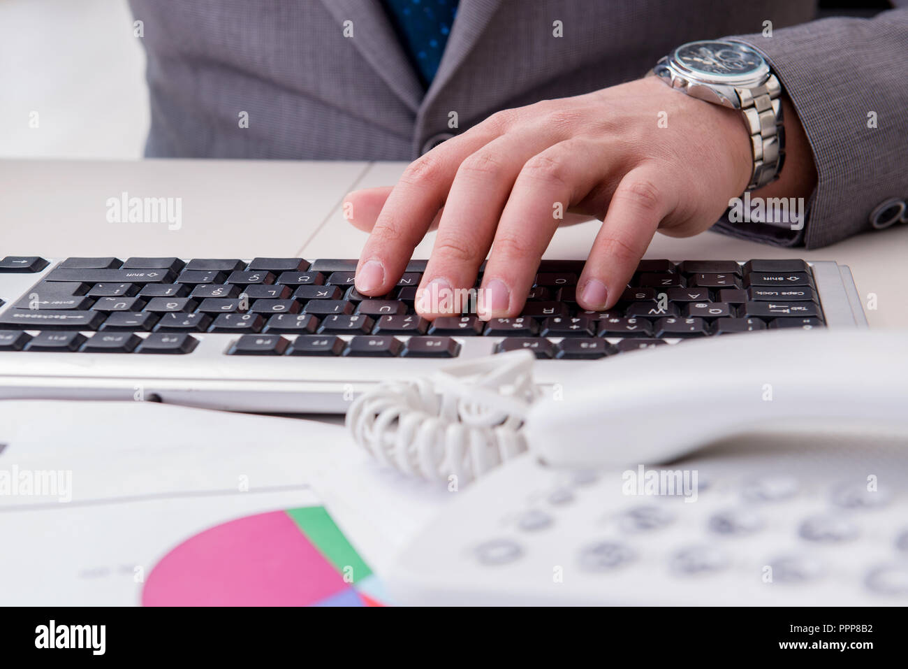 Finance professional working on keyboard with reports Stock Photo - Alamy