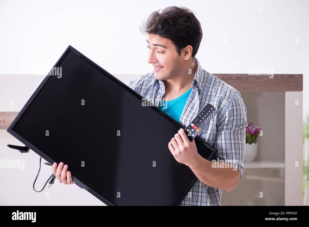 Man trying to fix broken tv Stock Photo - Alamy