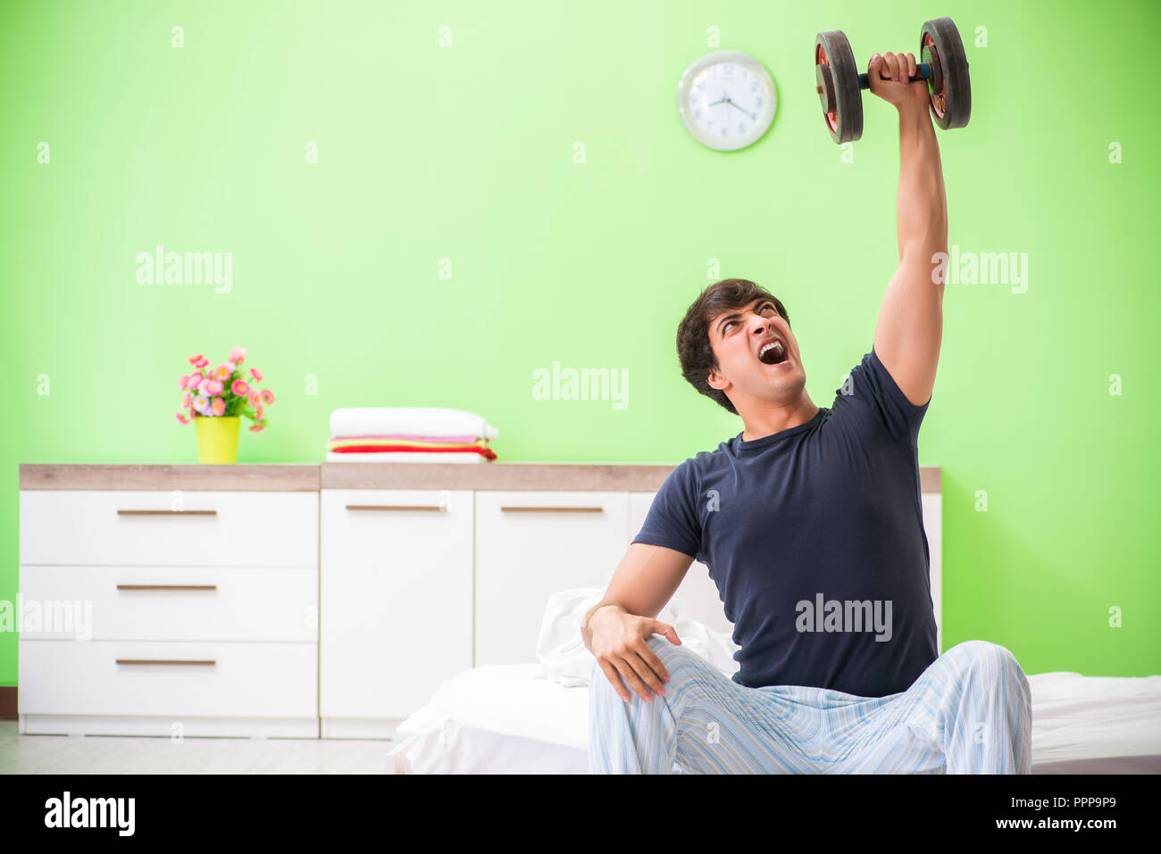 Young man in pajamas doing morning exercises Stock Photo - Alamy