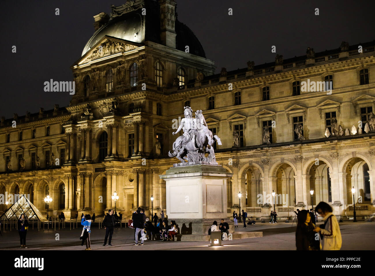 Night Louvre and tourists walking in Paris, France. Concept of French ...