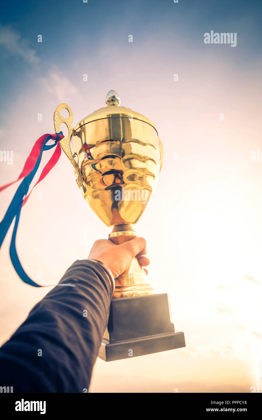 Hand holding winner trophy Stock Photo - Alamy