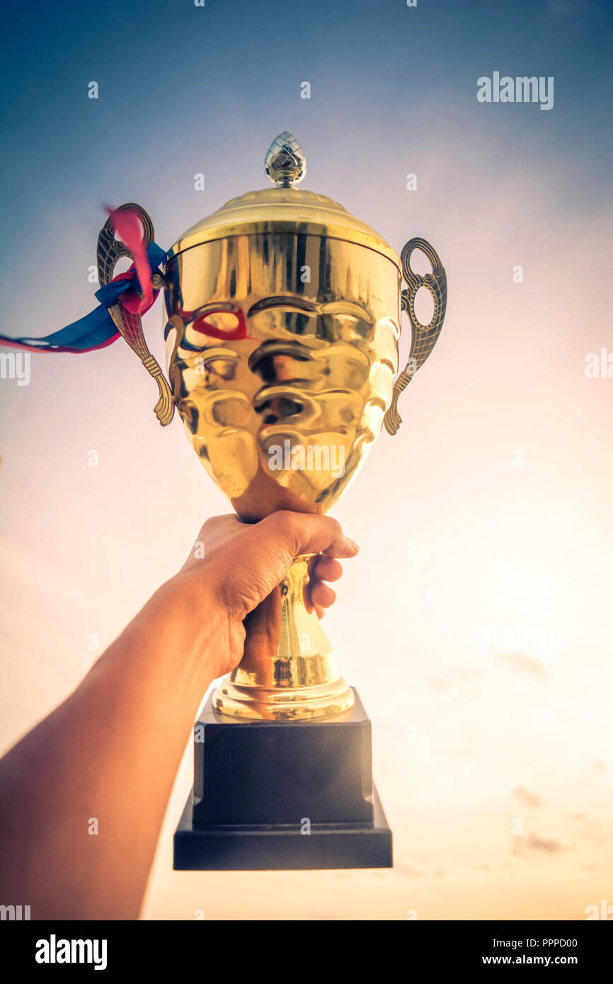 Hand holding winner trophy Stock Photo - Alamy