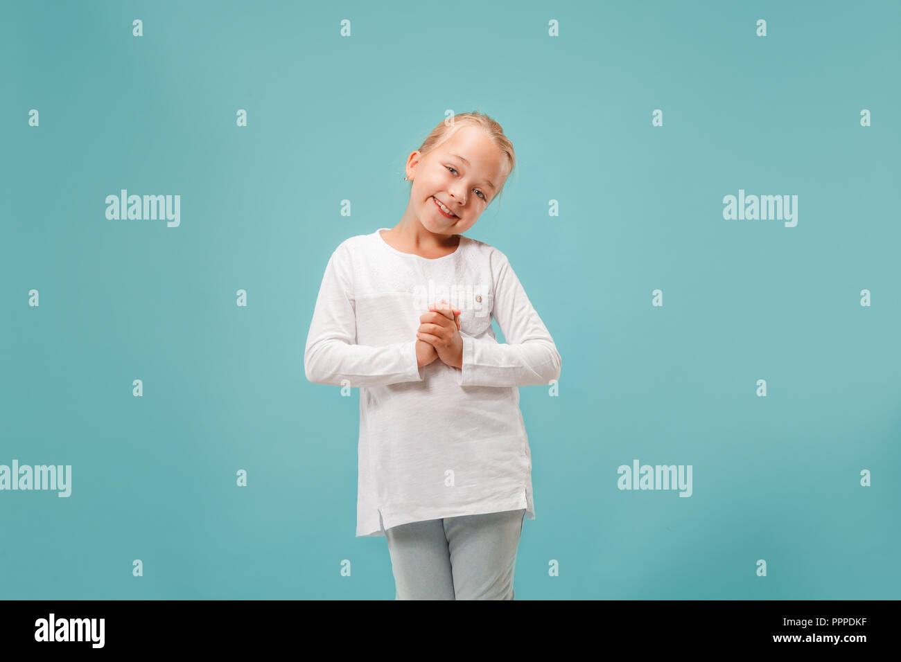 Happy teen girl standing, smiling isolated on trendy blue studio ...