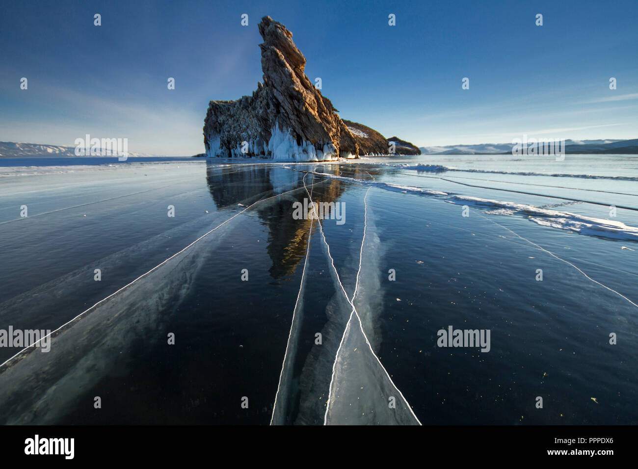 Lake is covered with a thick layer of ice. Ice story. Stone rock ...