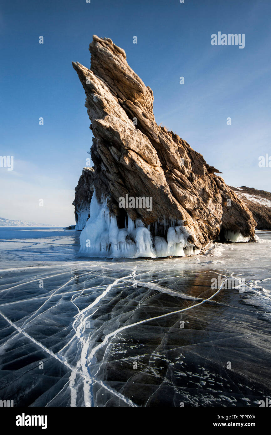 Lake is covered with a thick layer of ice. Ice story. Stone rock ...